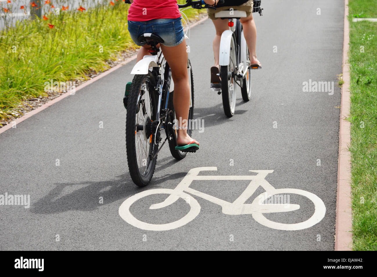 Bicycle road sign and bike riders Stock Photo - Alamy
