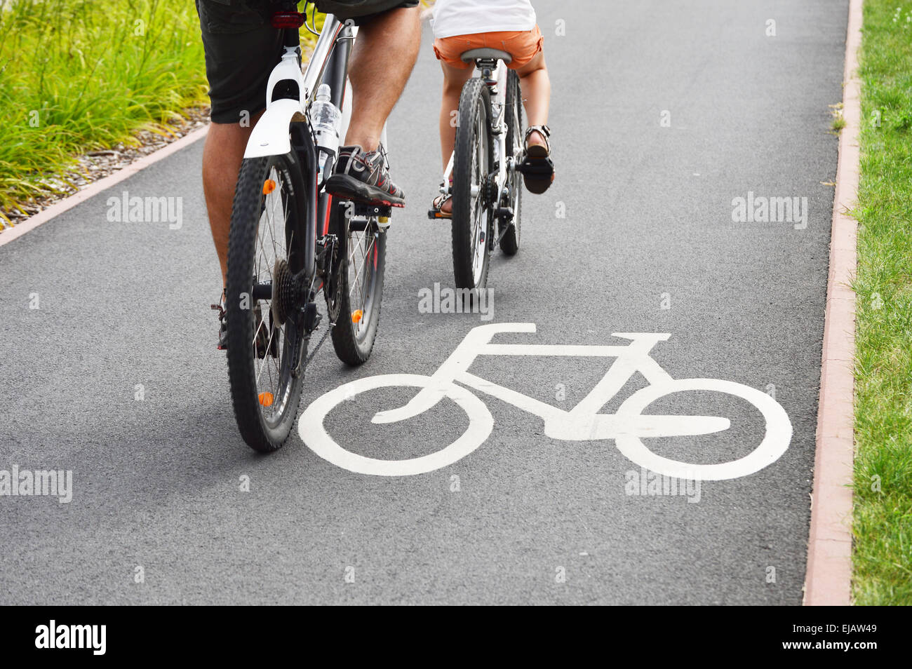 Bicycle road sign and bike riders Stock Photo - Alamy