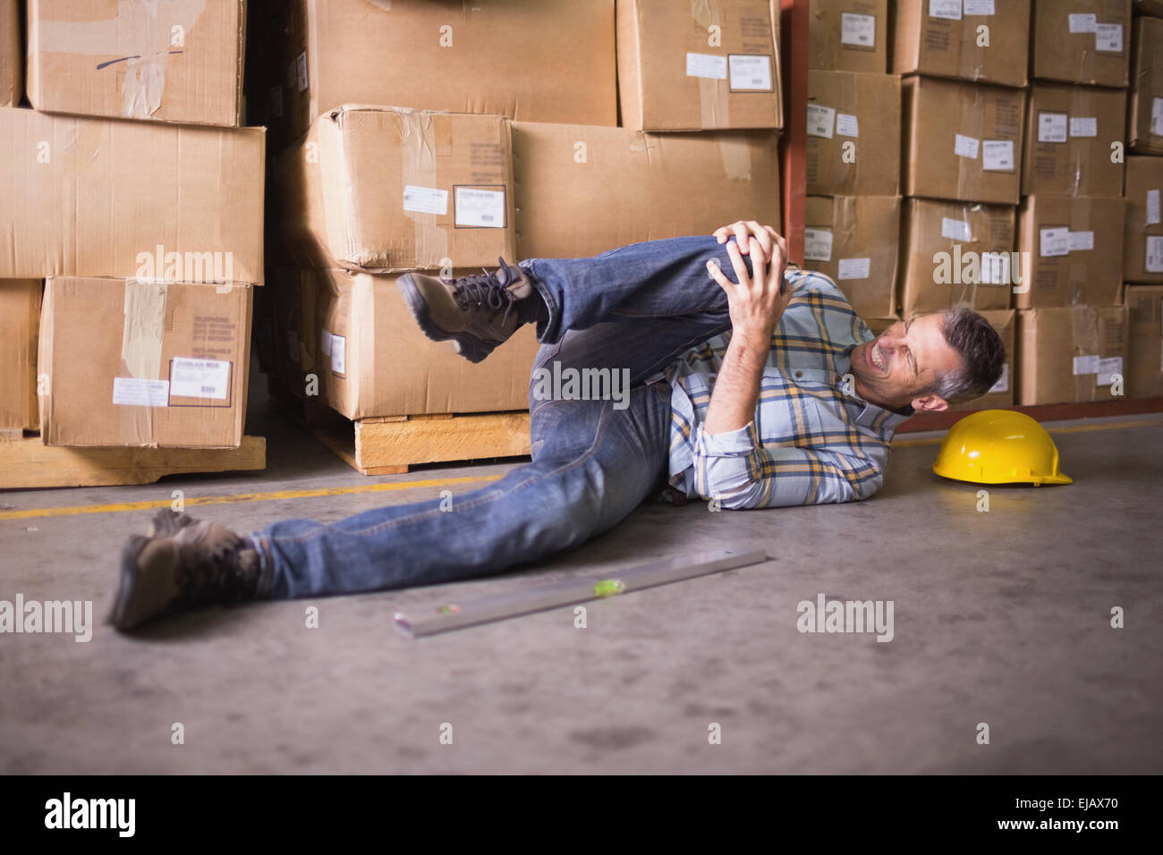 Worker lying on the floor in warehouse Stock Photo - Alamy