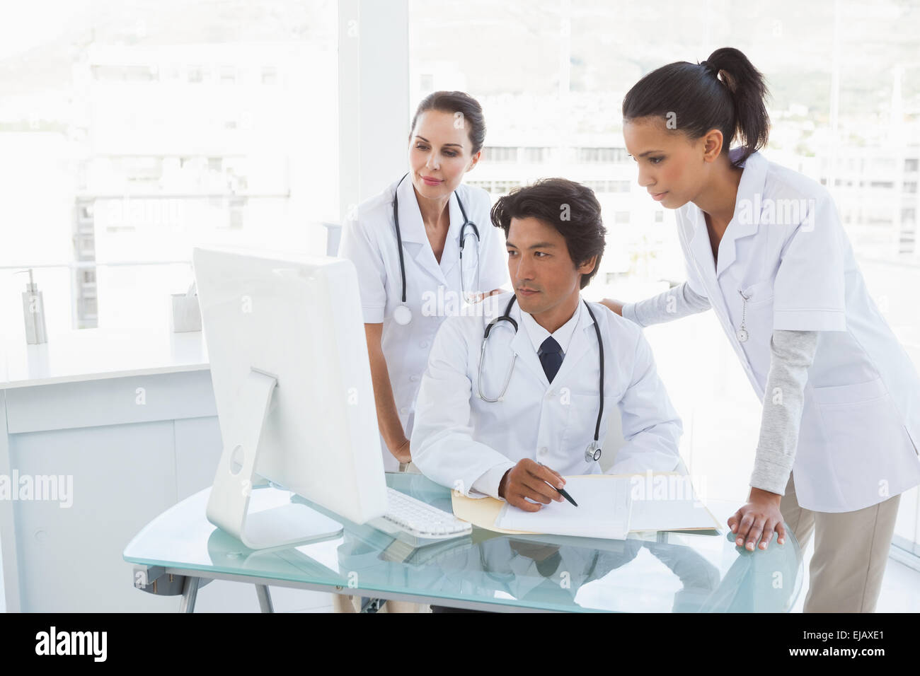 Doctors looking at a computer Stock Photo - Alamy