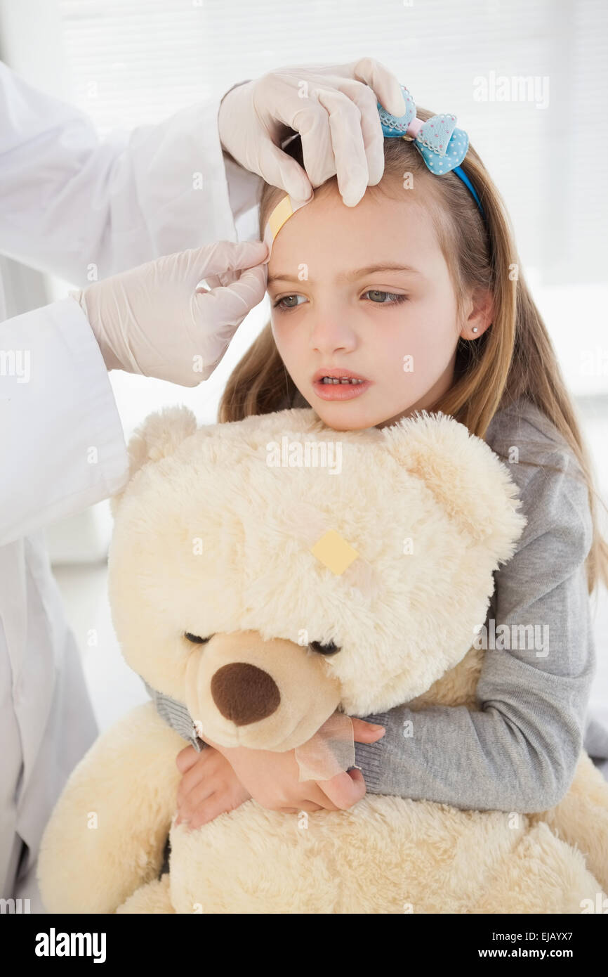 Girl getting a bandage on her forehead Stock Photo - Alamy