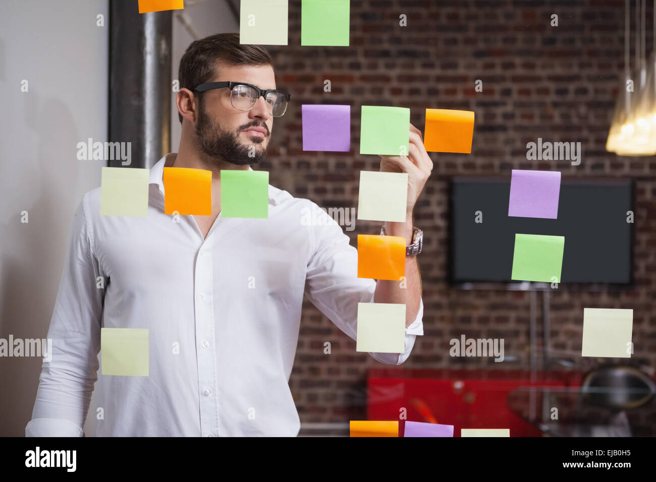 Casual businessman writing on sticky notes Stock Photo - Alamy