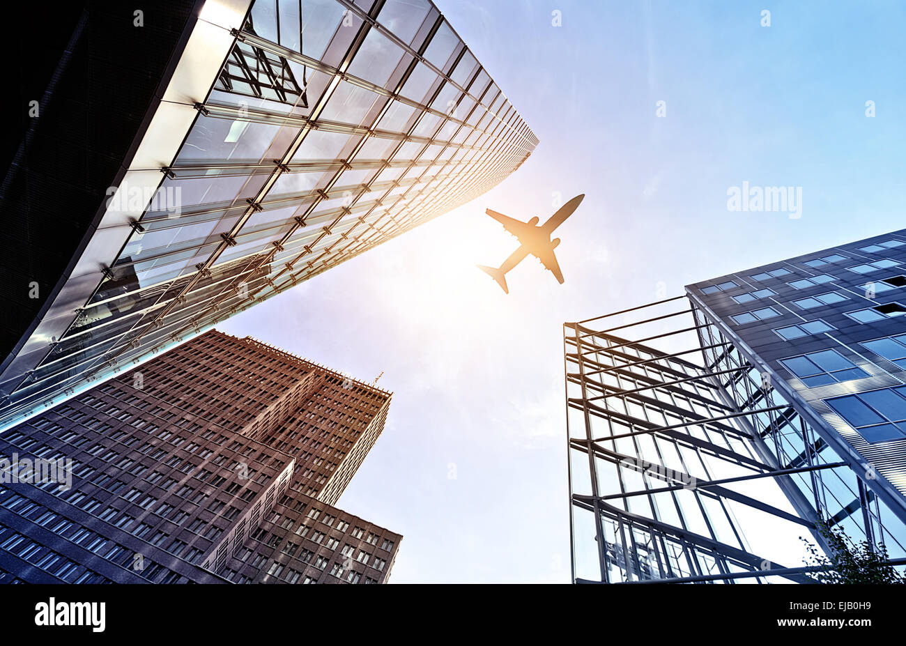plane over office towers Stock Photo - Alamy