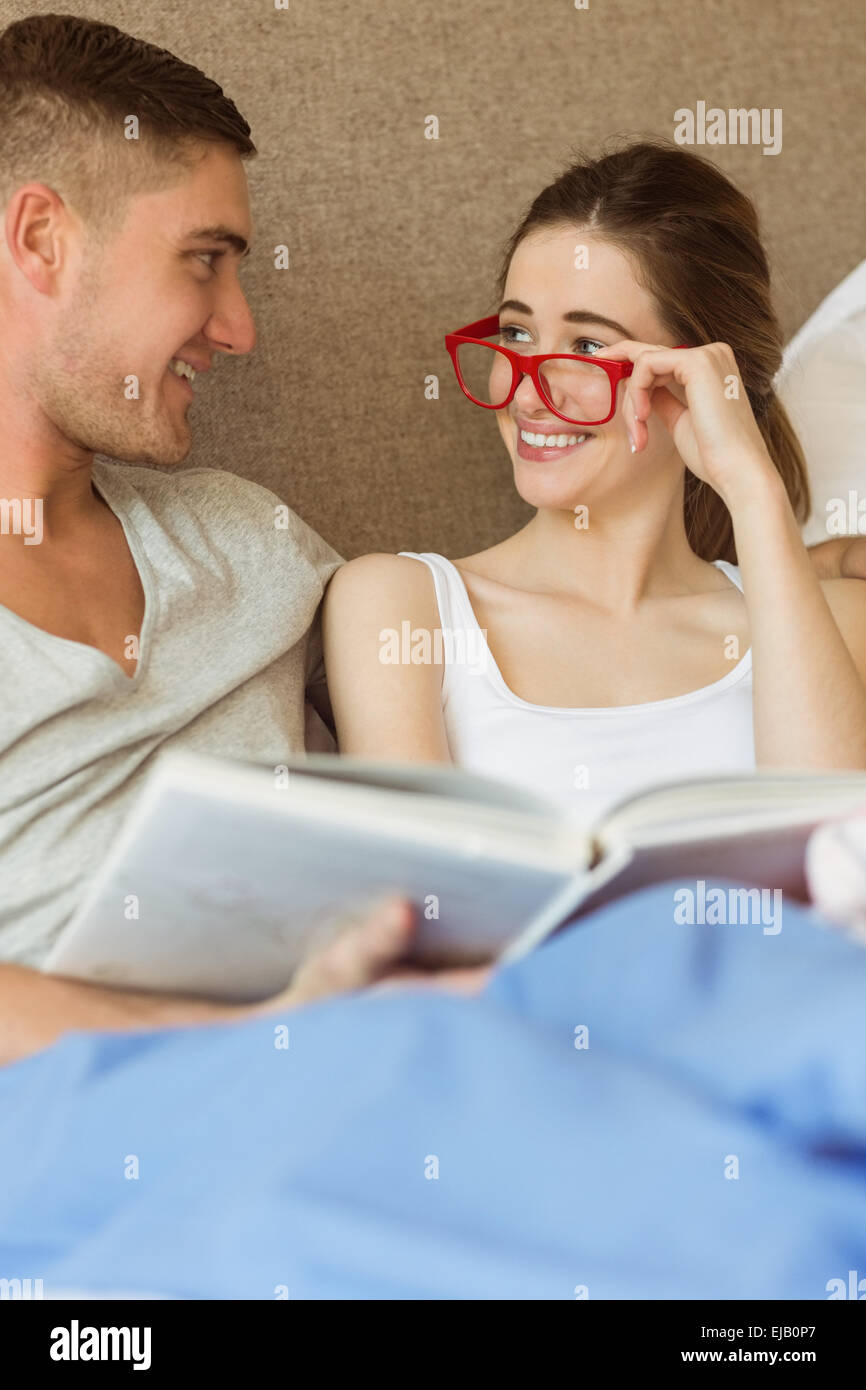 Cute couple reading book in bed Stock Photo - Alamy
