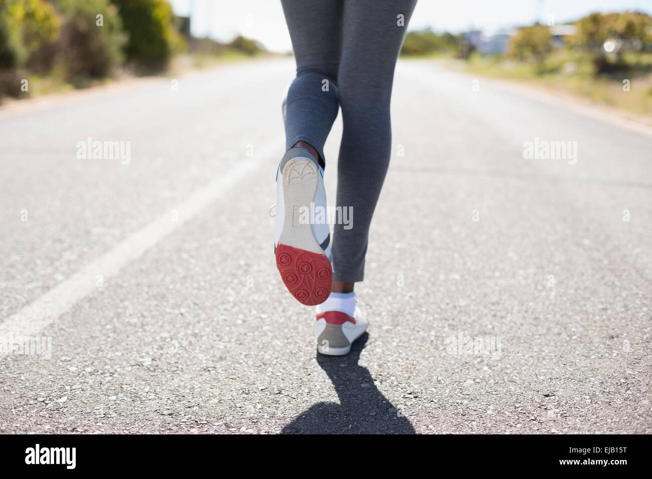Fit woman running up the open road Stock Photo - Alamy