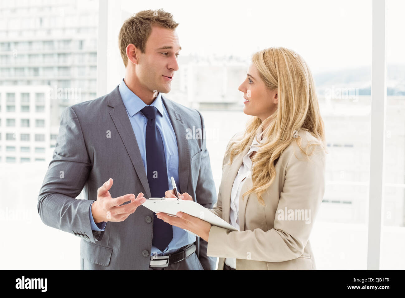 Businessman talking to his secretary Stock Photo - Alamy