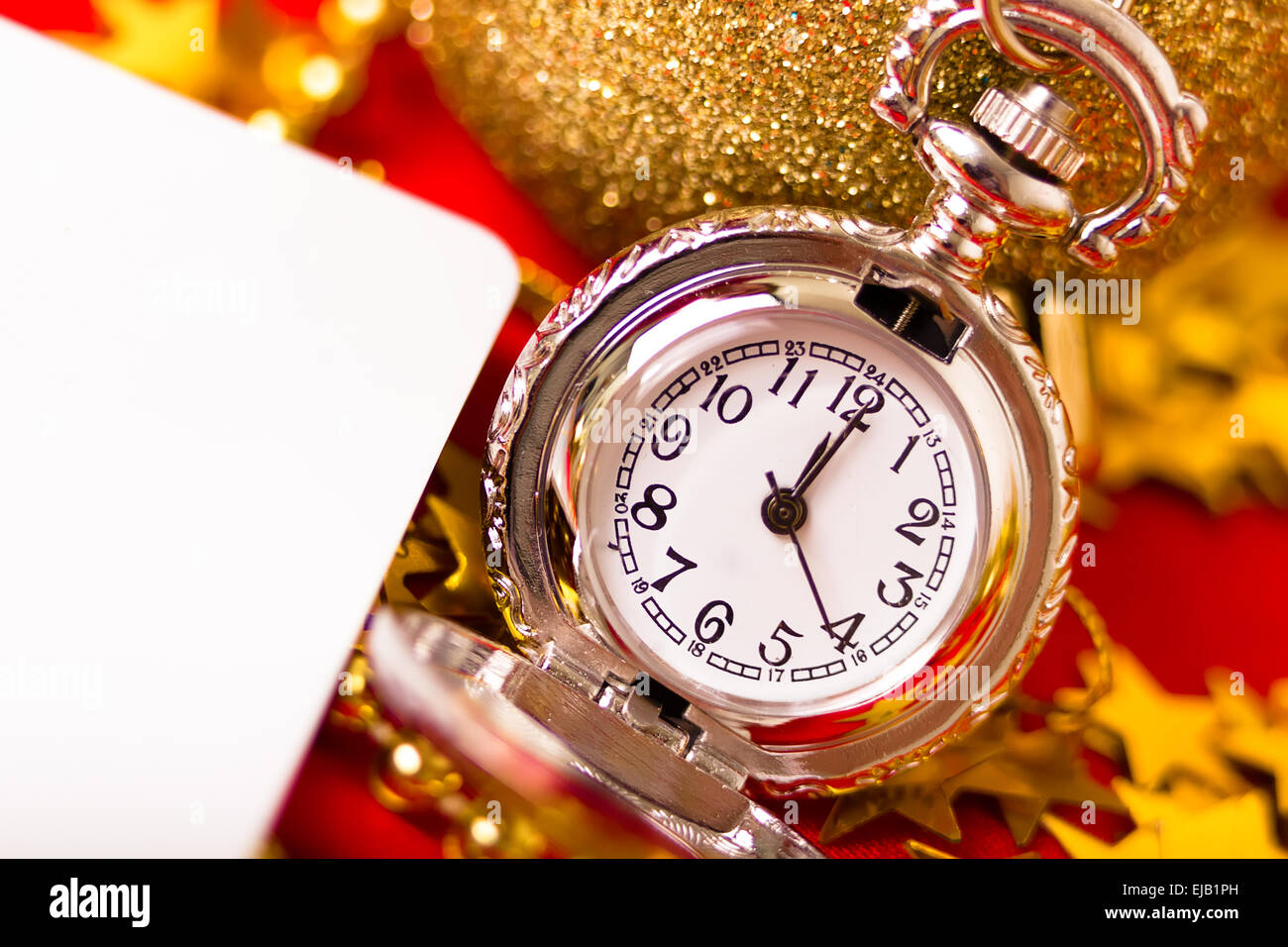 Christmas card. Silver vintage pocket watch on a red background with ...