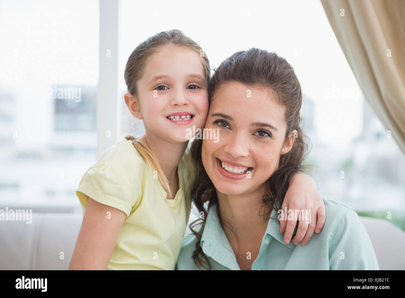 Cute mother and daughter smiling at camera Stock Photo - Alamy