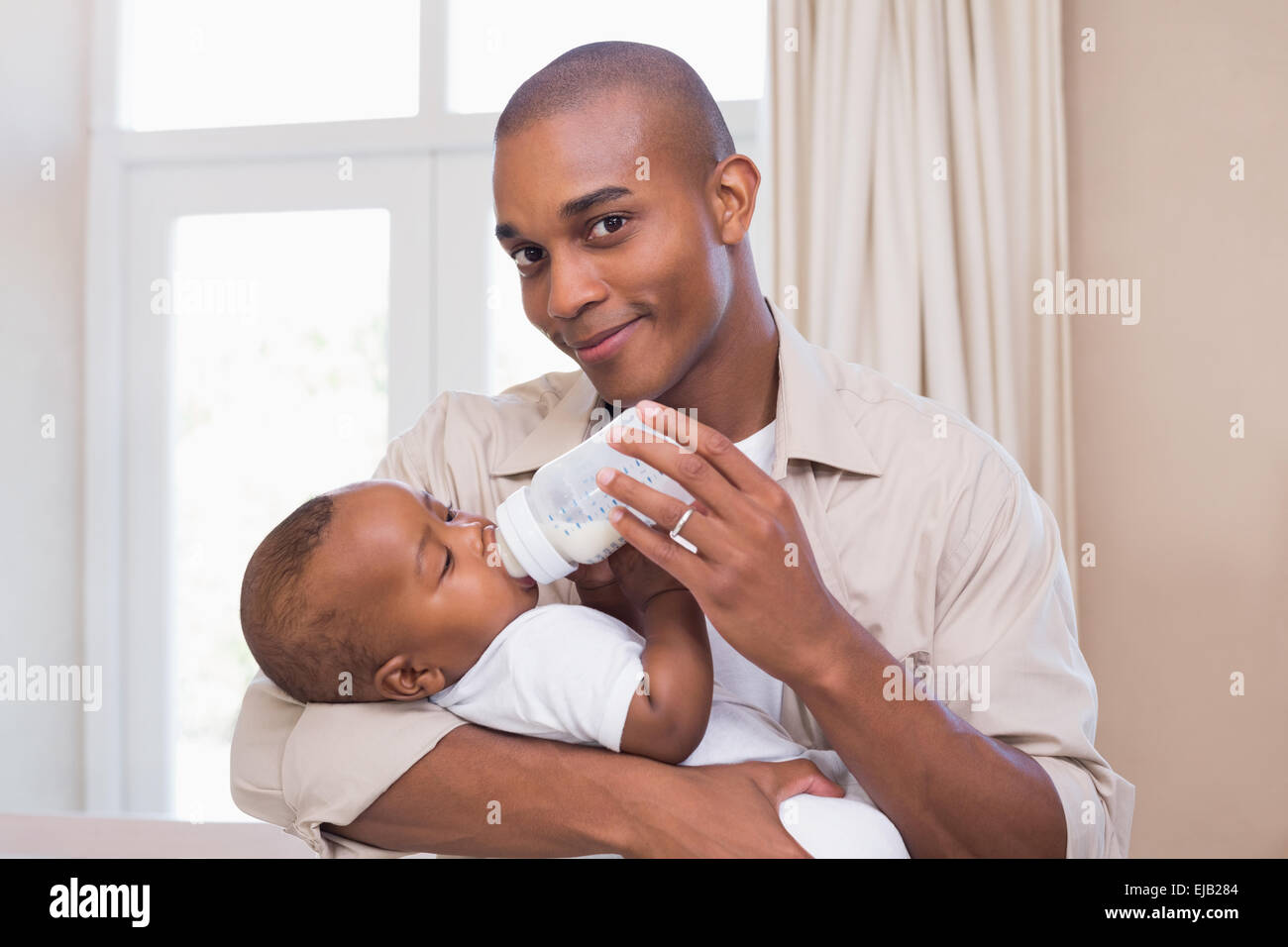 Happy father feeding his baby boy a bottle Stock Photo - Alamy