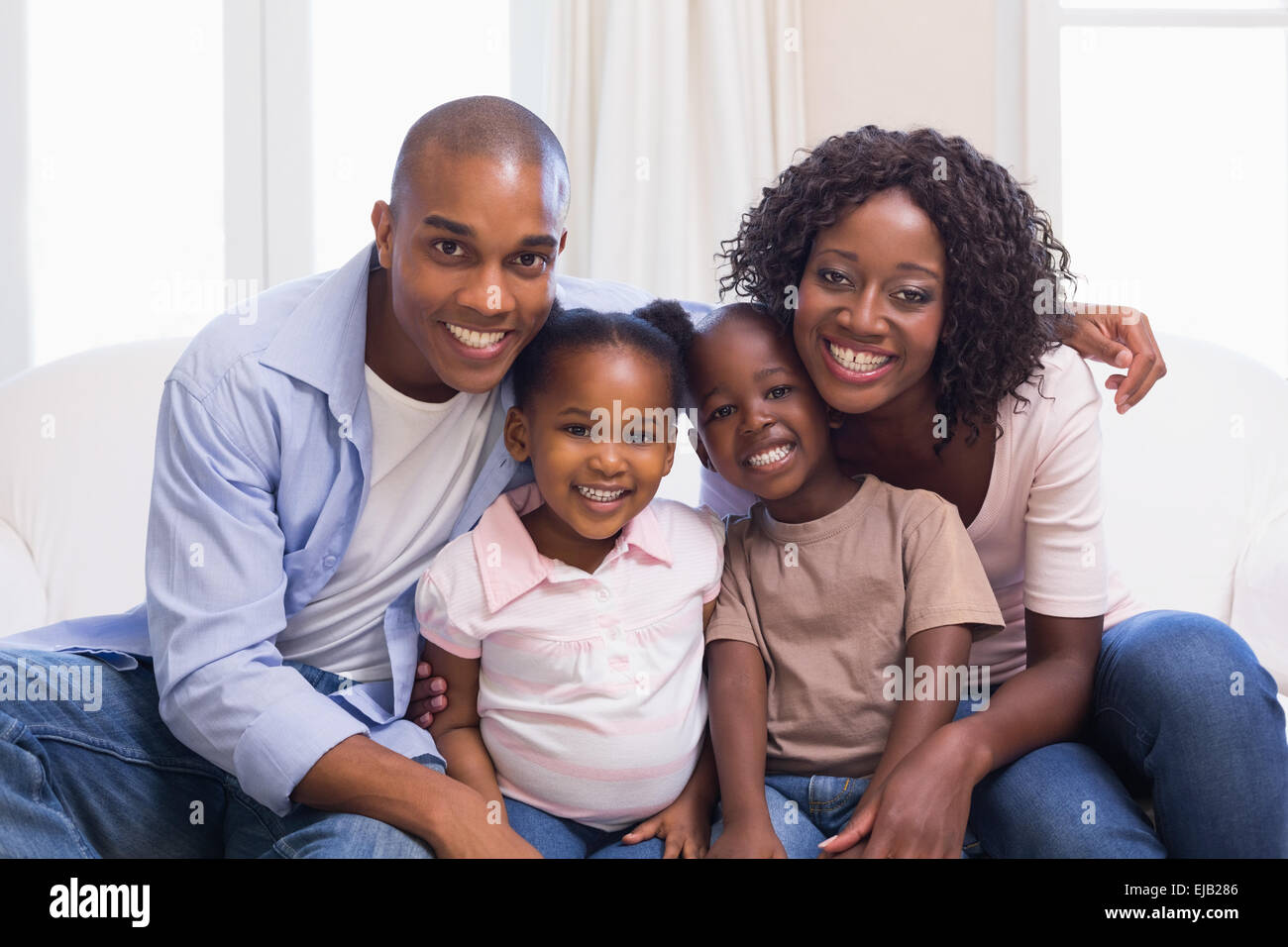 Happy family smiling at camera together Stock Photo - Alamy