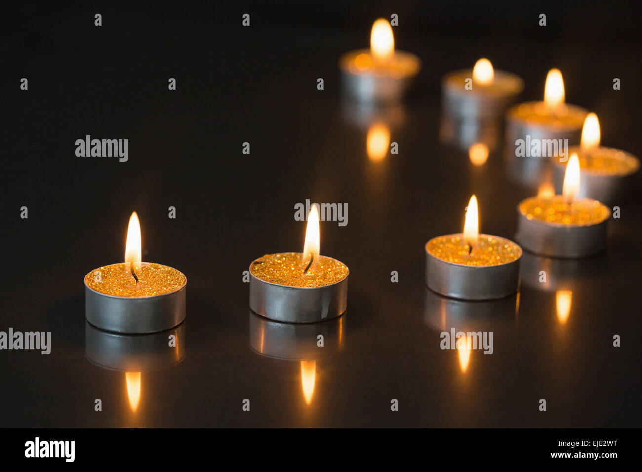 Eight small candles burning Stock Photo - Alamy