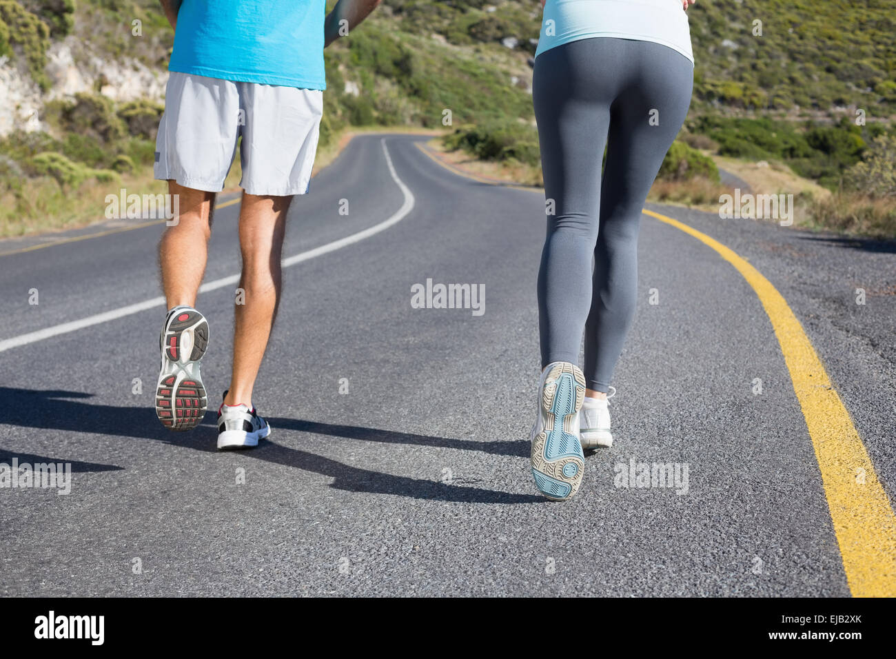 Fit couple running together down a road Stock Photo - Alamy