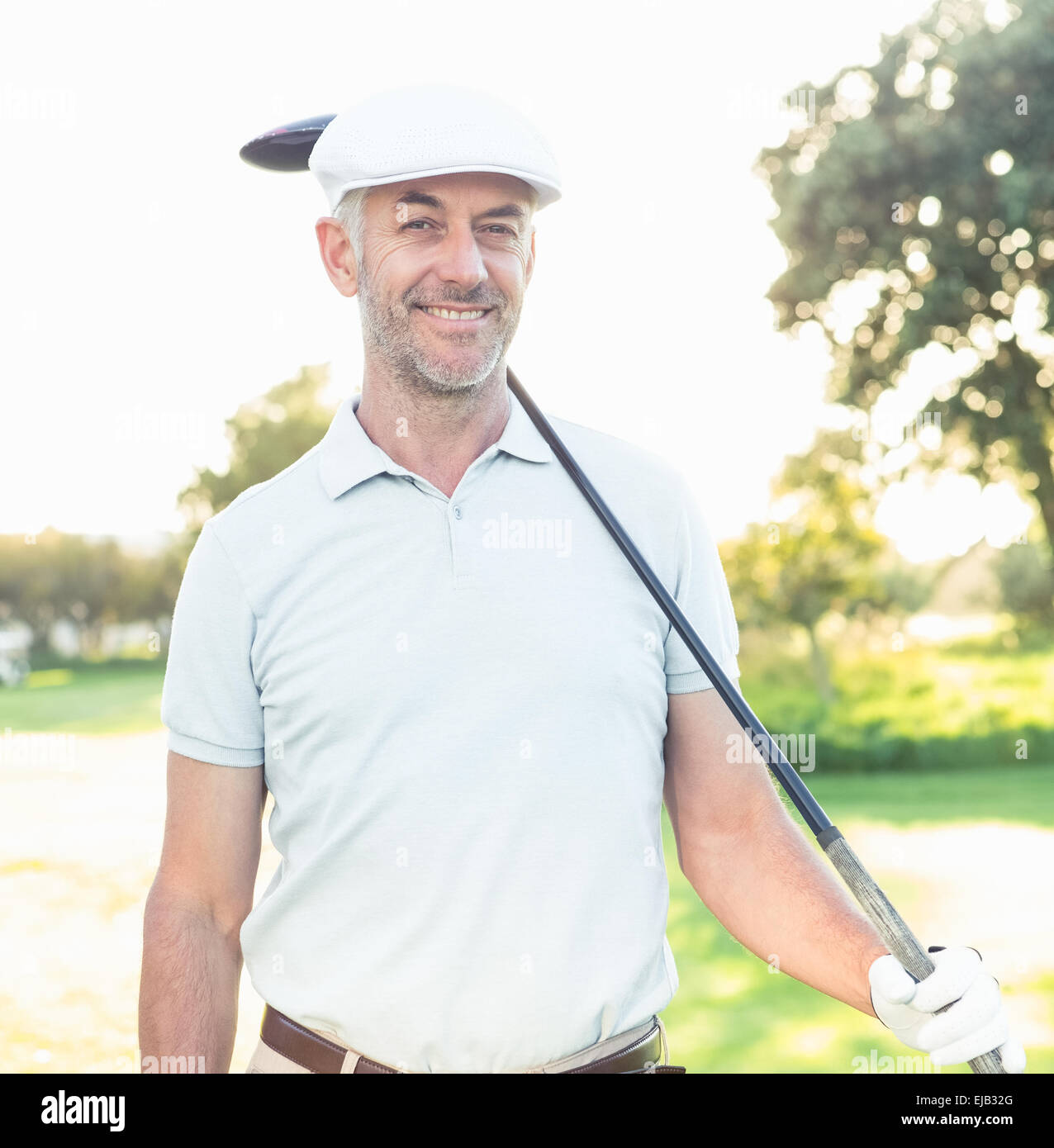 Smiling handsome golfer looking away Stock Photo - Alamy