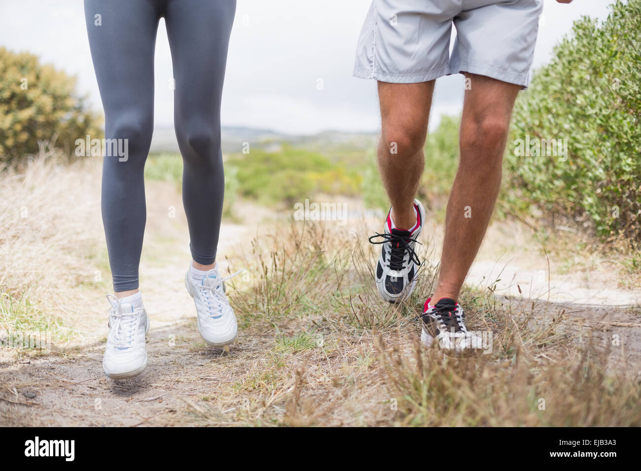 Fit couple jogging on mountain trail Stock Photo - Alamy