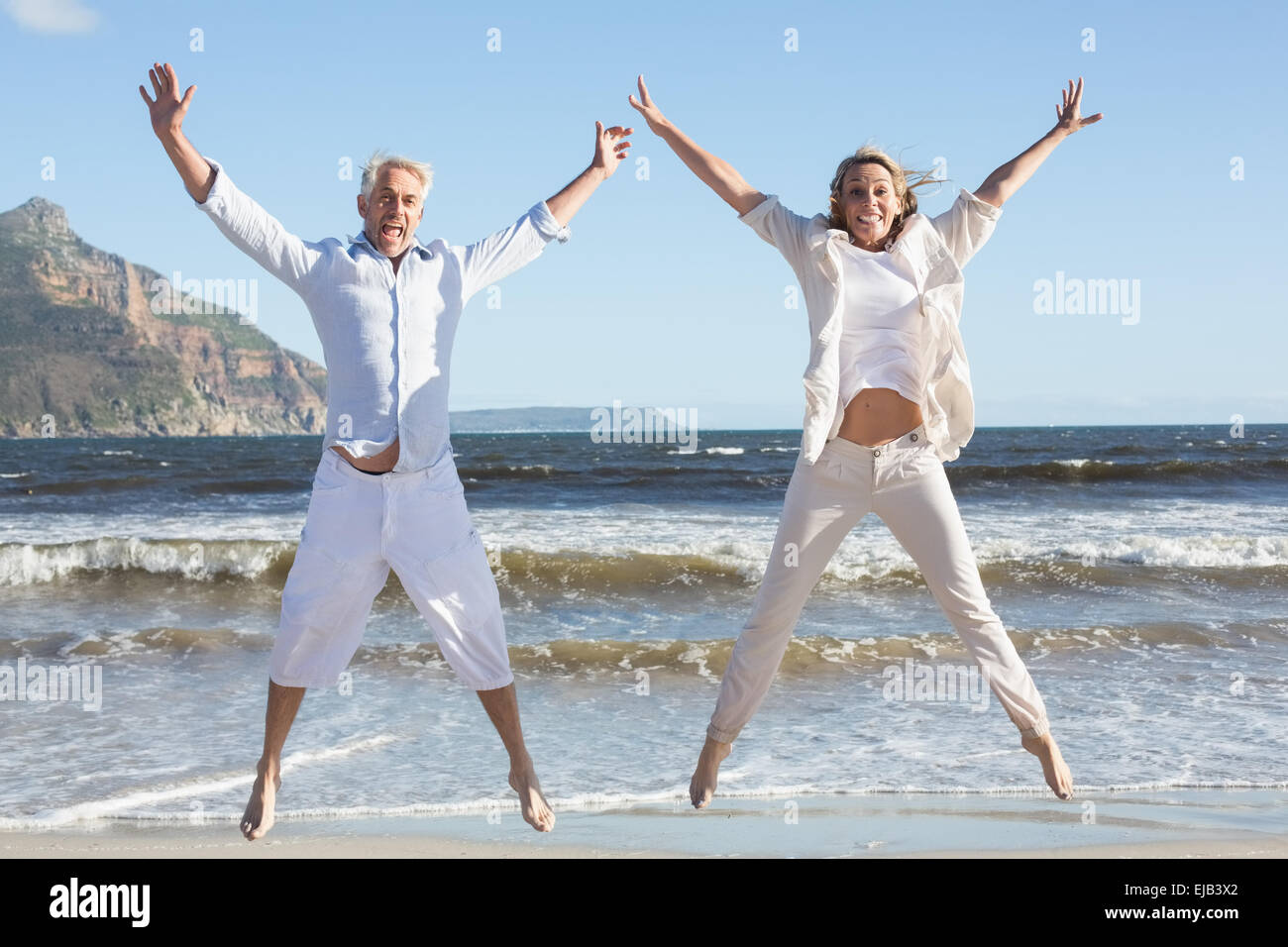 Happy couple jumping on the beach together Stock Photo - Alamy
