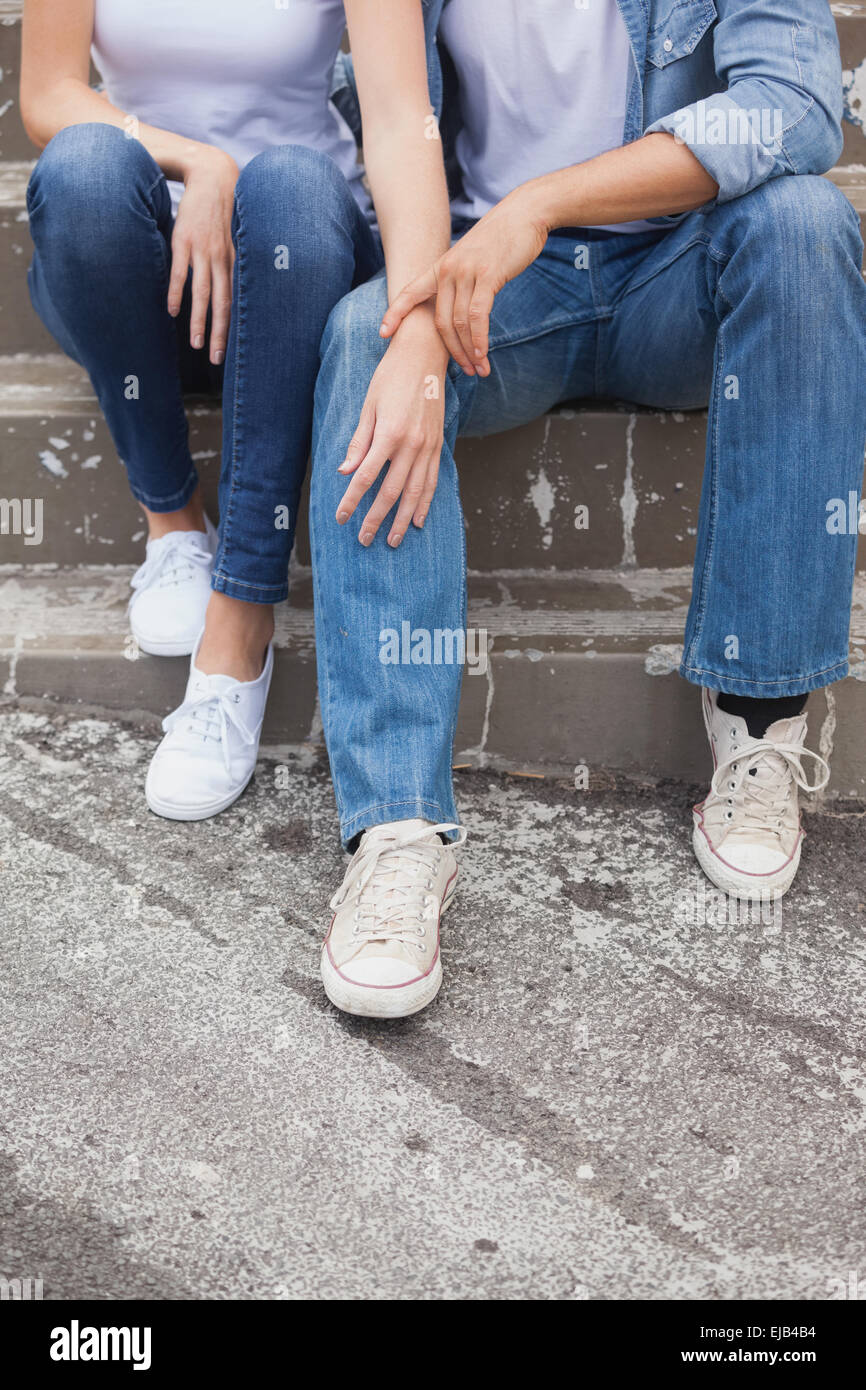 Hip young couple in denim sitting on steps Stock Photo - Alamy