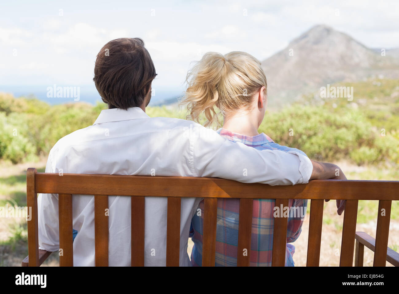 Cute couple sitting on bench together Stock Photo - Alamy