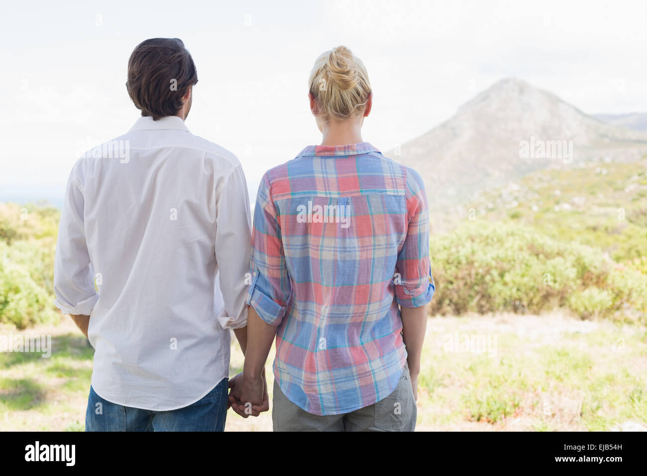 Cute couple standing hand in hand Stock Photo - Alamy