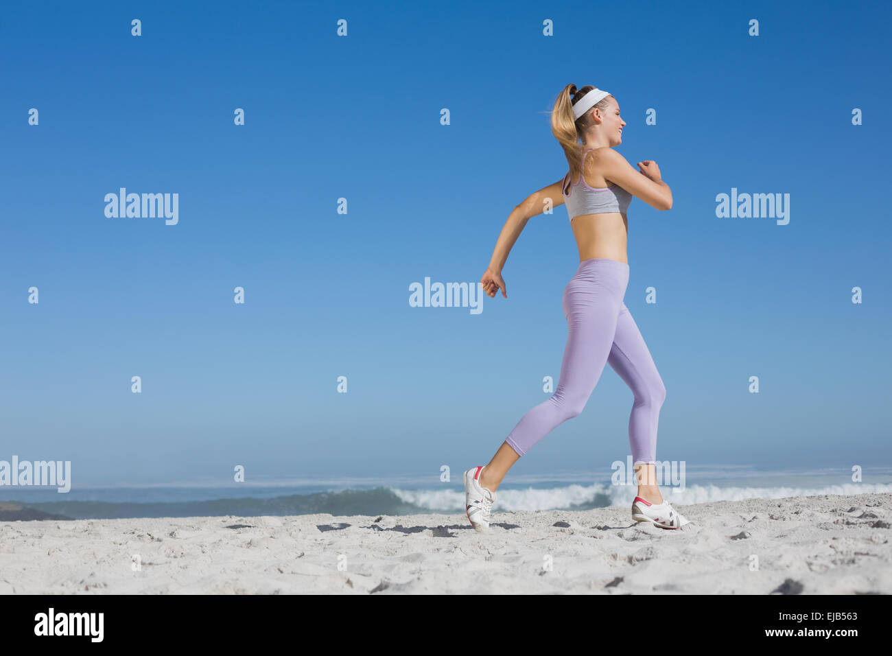 Sporty blonde on the beach jogging Stock Photo - Alamy