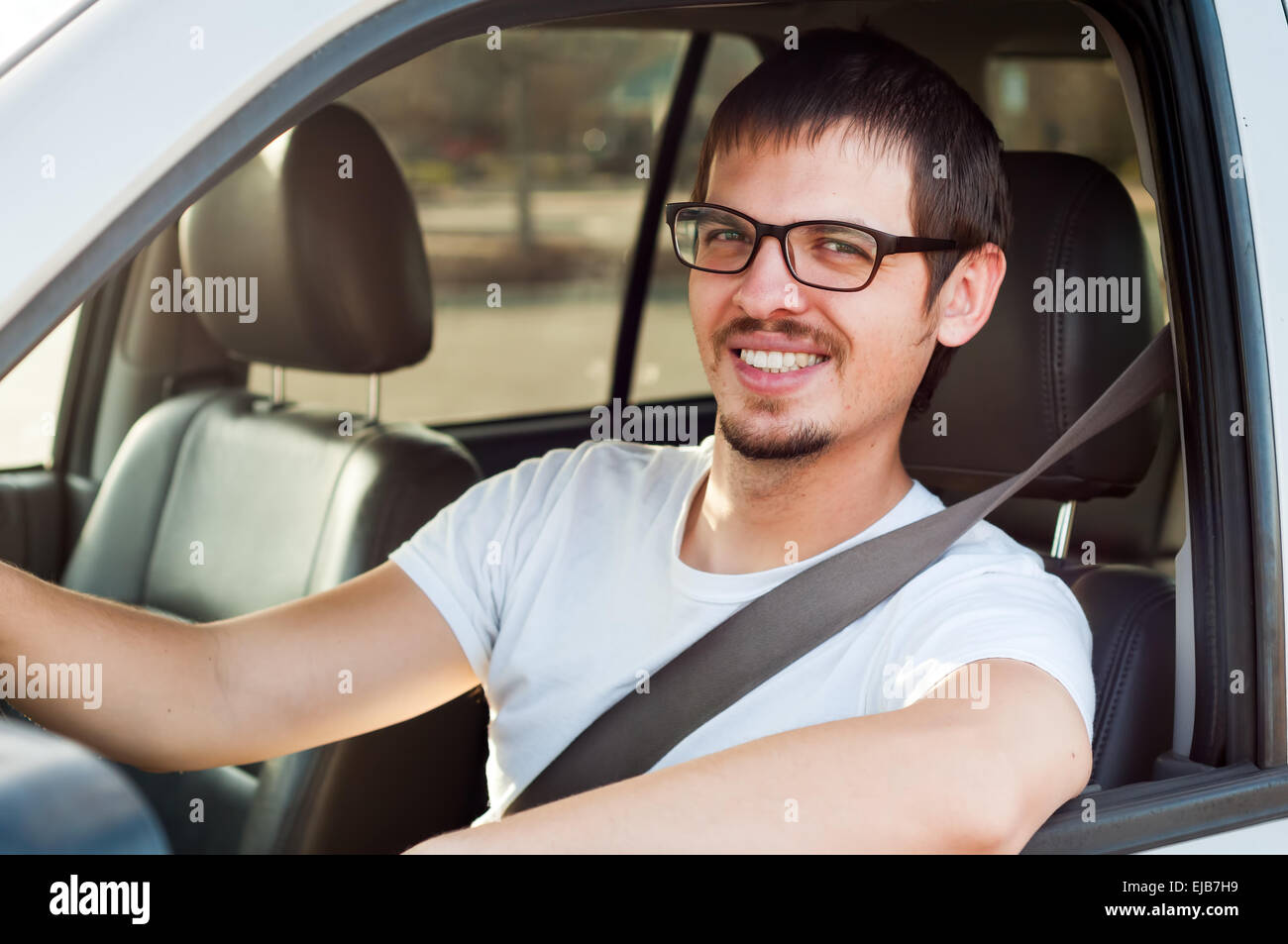 Male european good driver is smiling in his car Stock Photo - Alamy