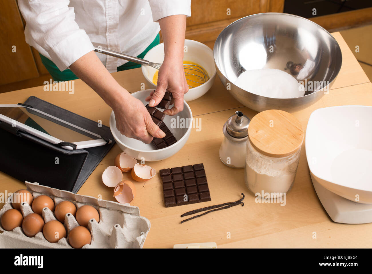 Woman hands breaking chocolate to make a cake Stock Photo - Alamy