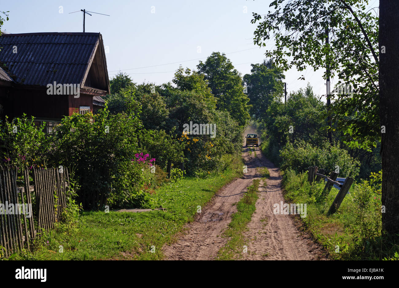 Rural landscape - village sand track road. On road the minibus with a ...