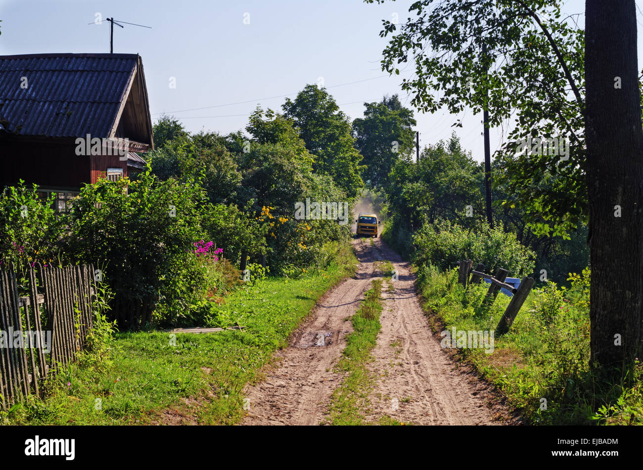 Rural landscape - village sand track road. On road the minibus with a ...