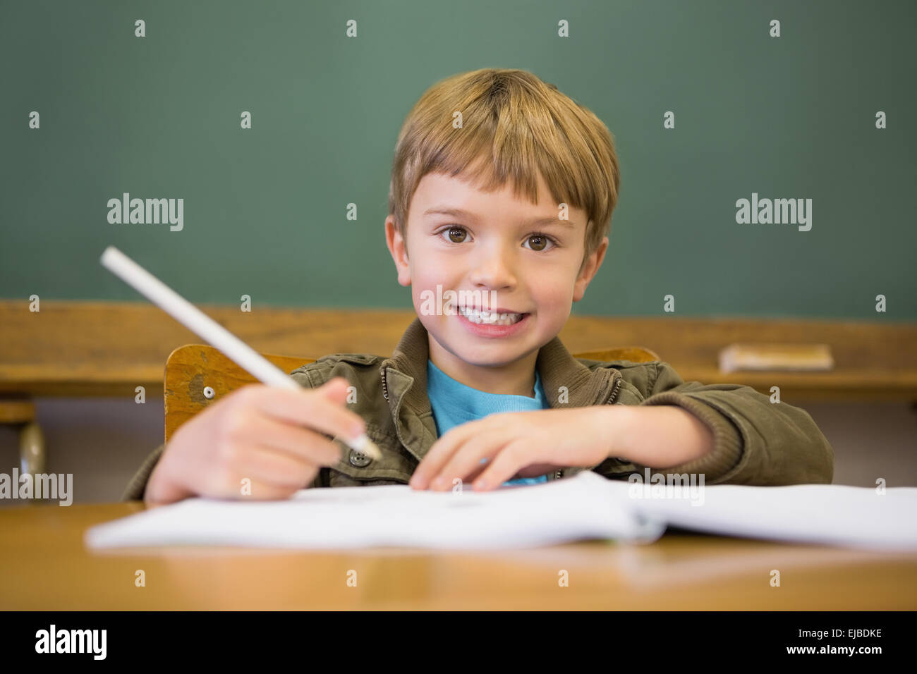 Happy pupil writing in notepad at desk Stock Photo - Alamy