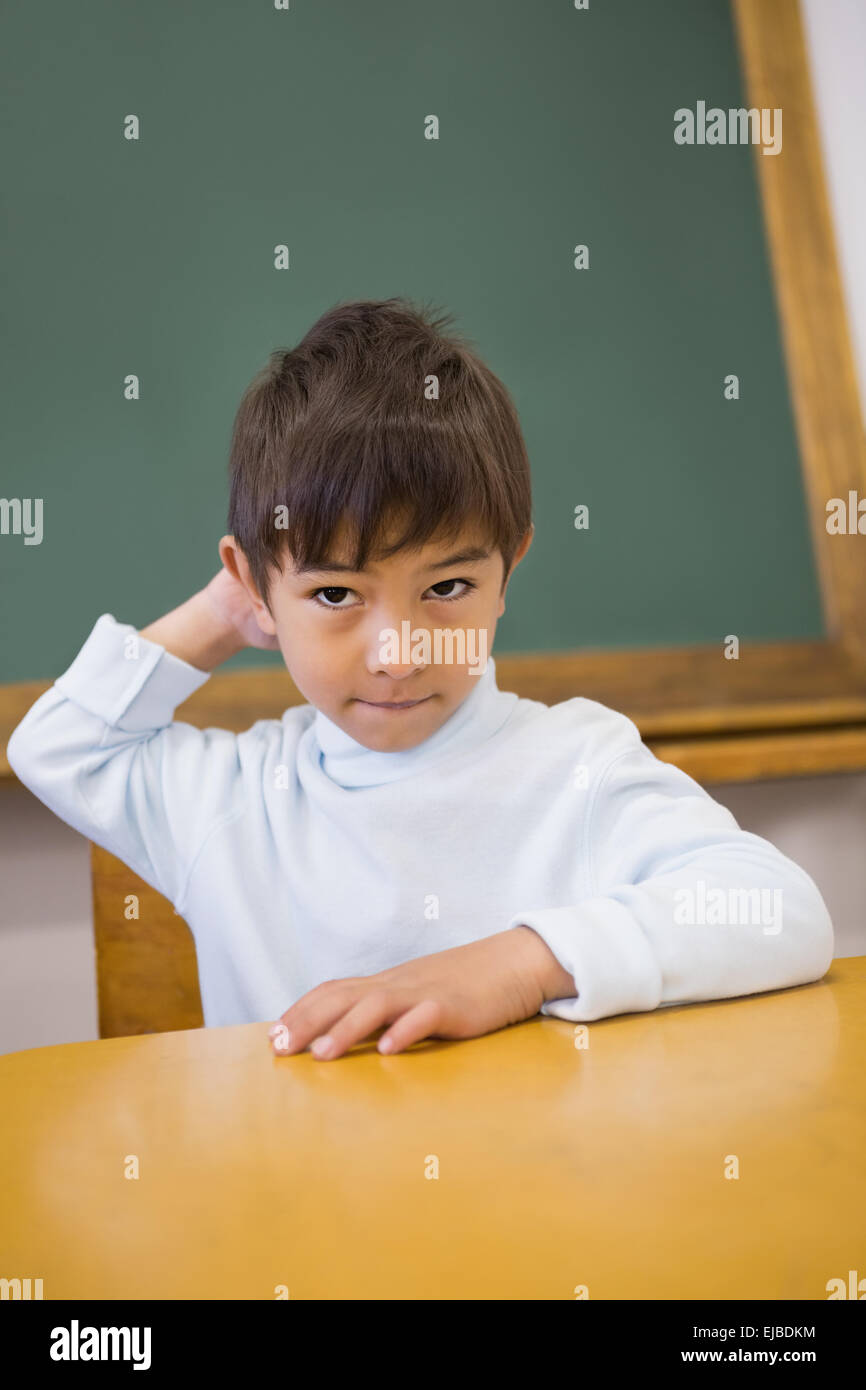 Cute pupil sitting at desk in classroom Stock Photo - Alamy