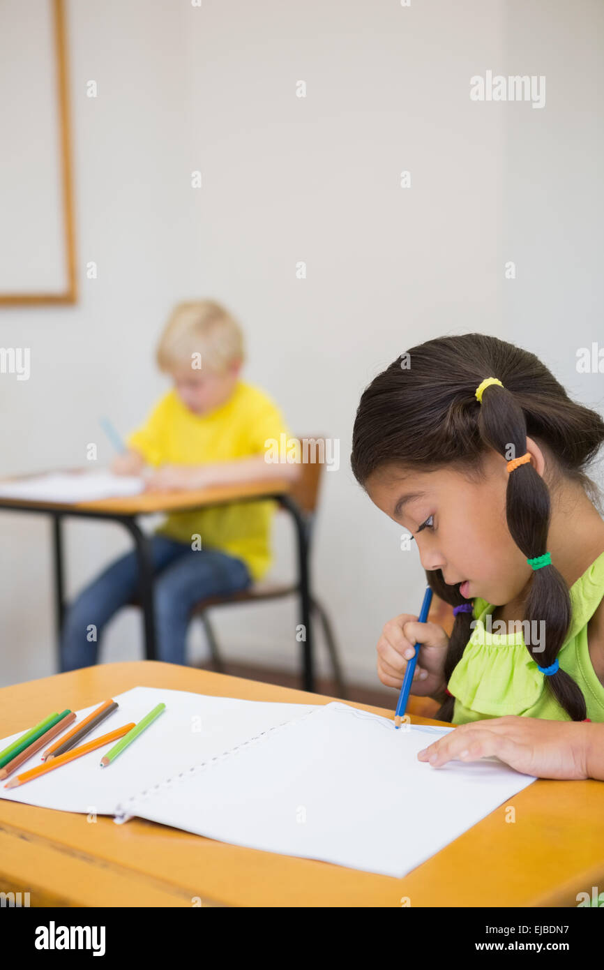 Cute pupils colouring at desks in classroom Stock Photo - Alamy