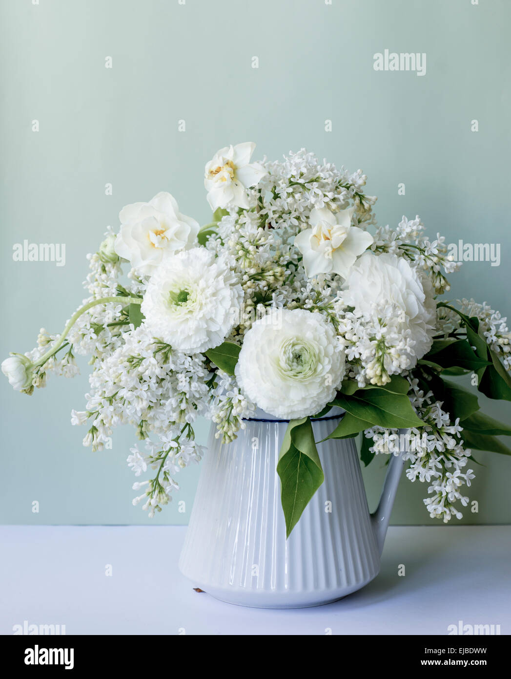 Spring flower arrangement with white ranunculus and lilac blossoms ...