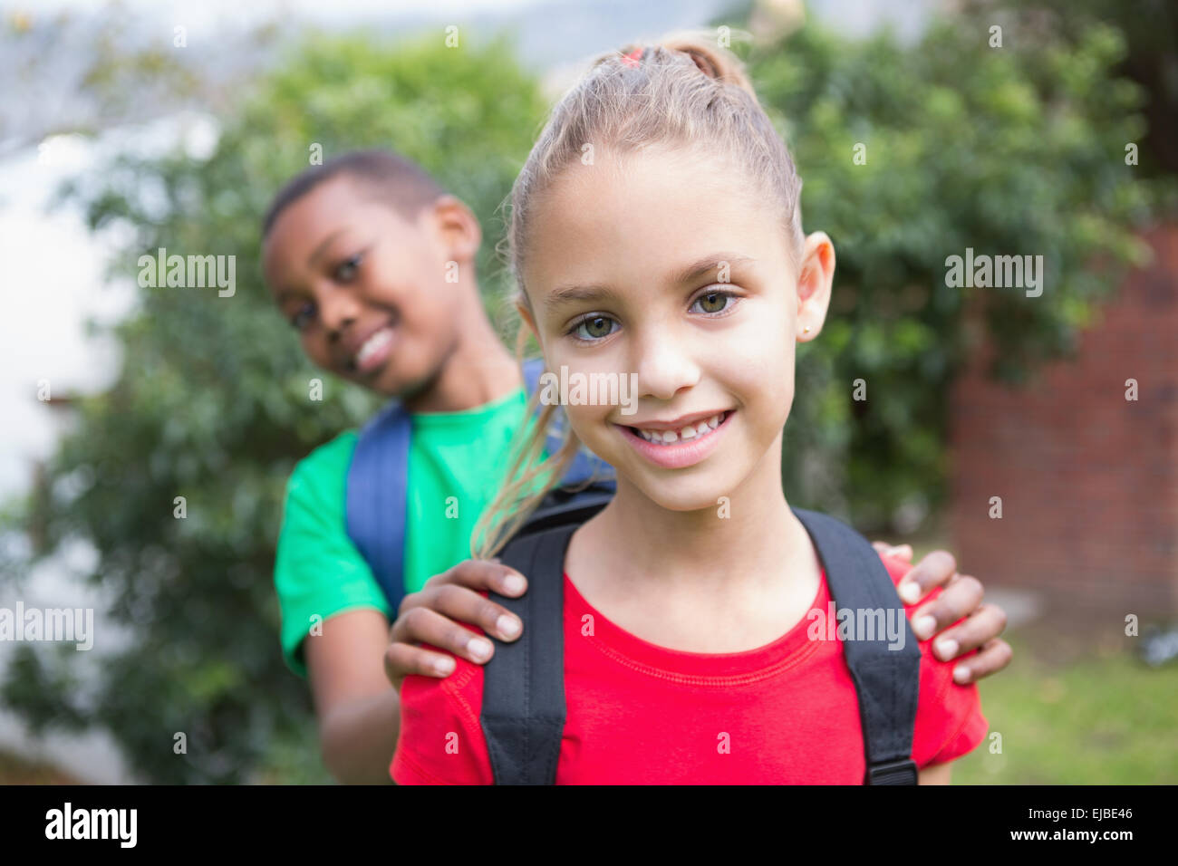 Cute pupils smiling at camera outside Stock Photo - Alamy