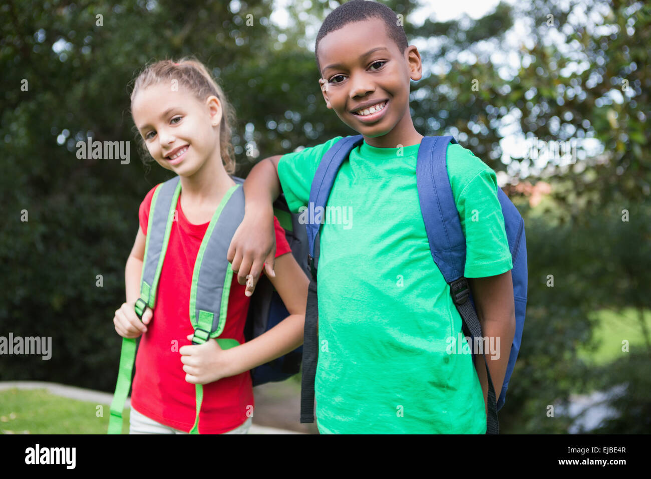 Cute pupils smiling at camera outside Stock Photo - Alamy