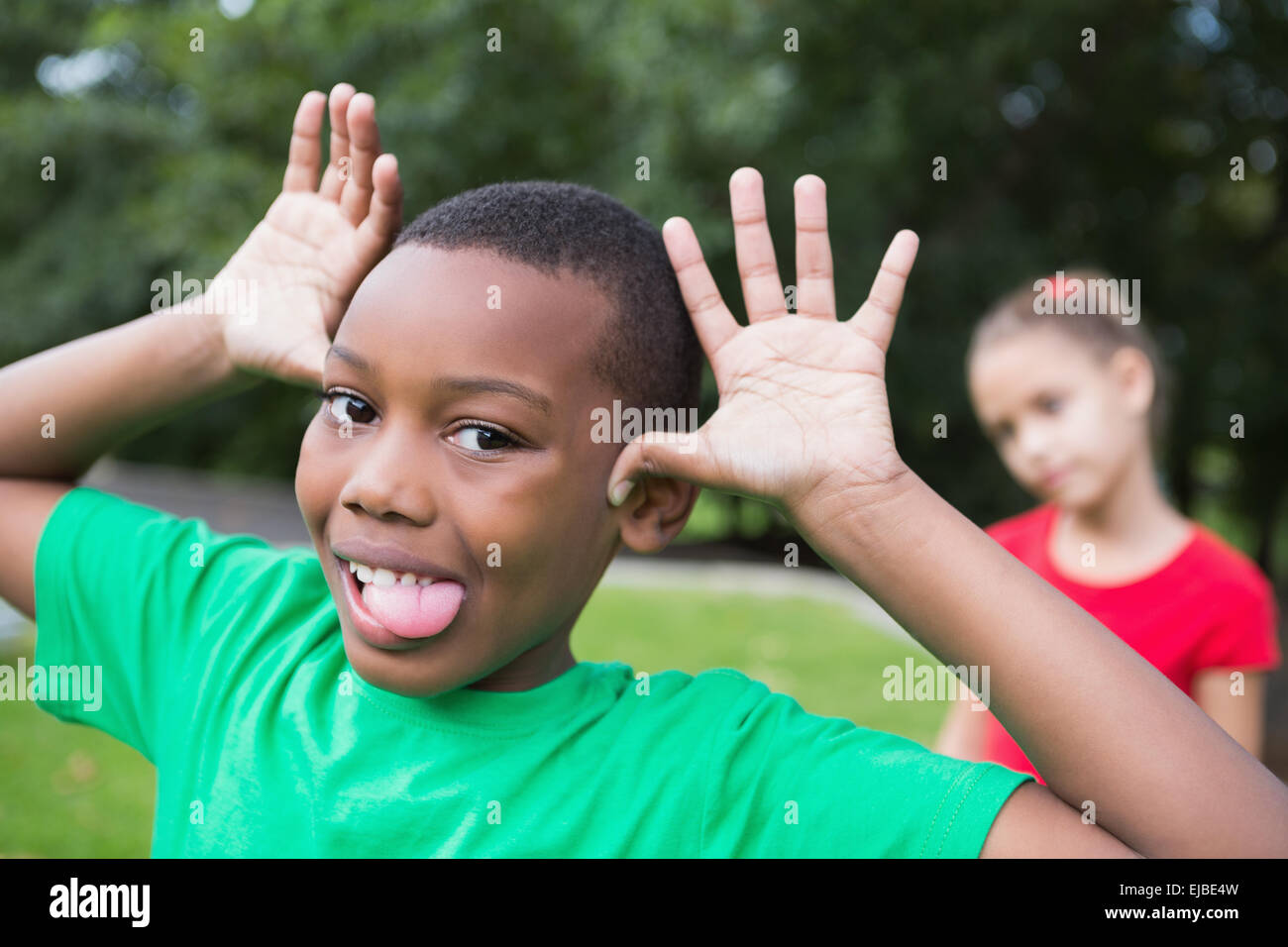Cute little boy making silly faces outside Stock Photo - Alamy