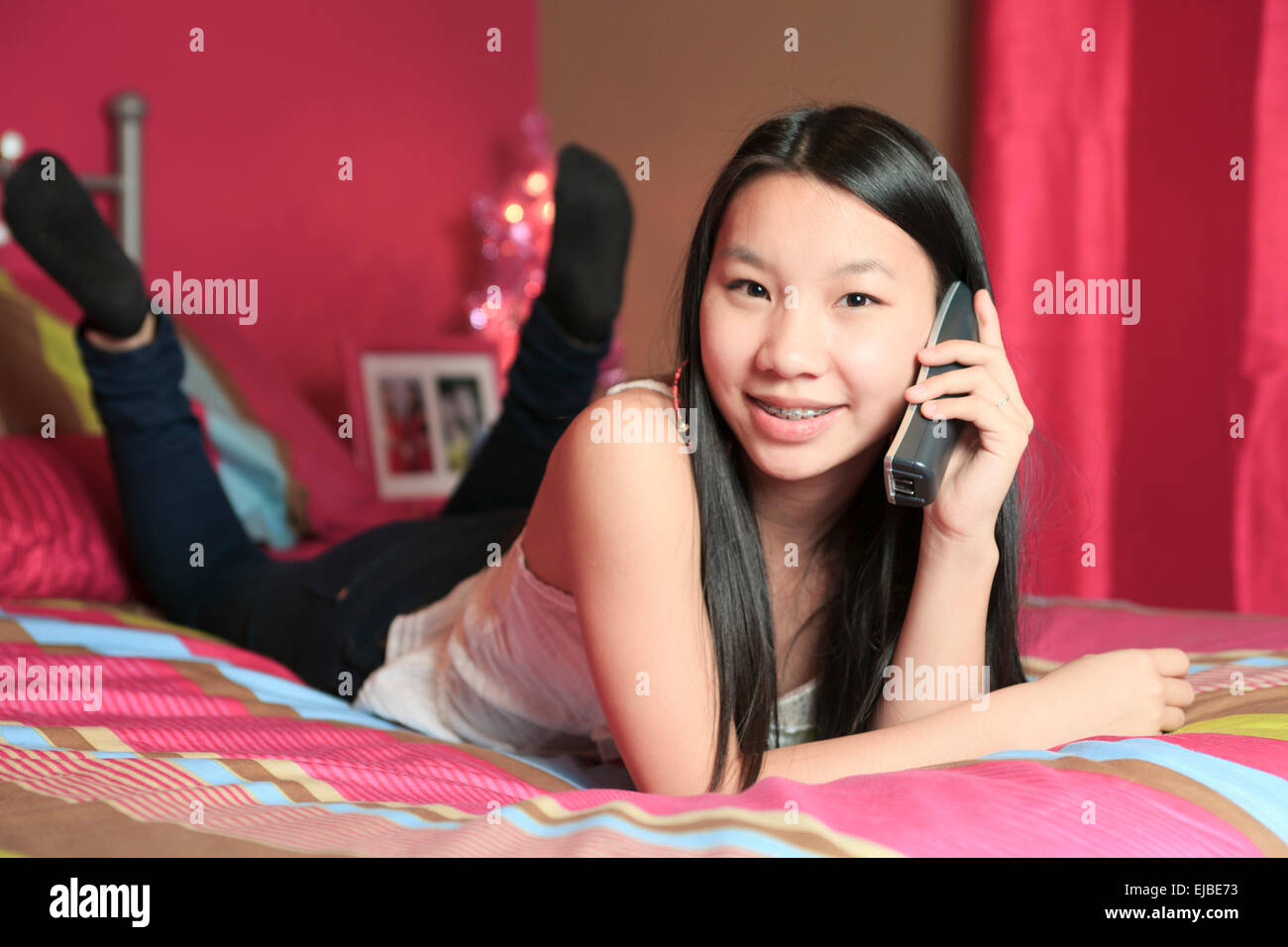 Girl in bedroom taling on the phone Stock Photo - Alamy
