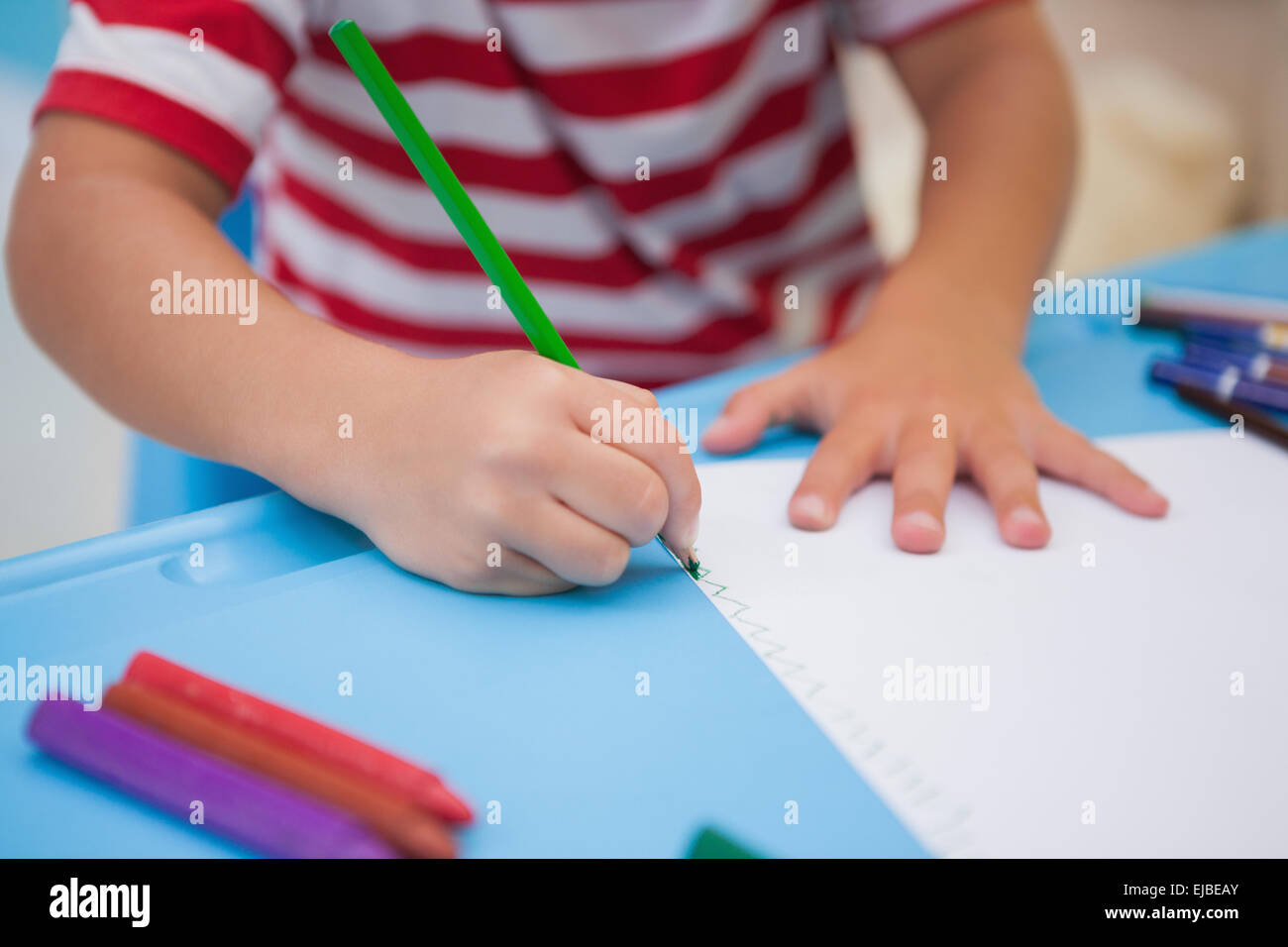 Cute little boy drawing at desk Stock Photo - Alamy