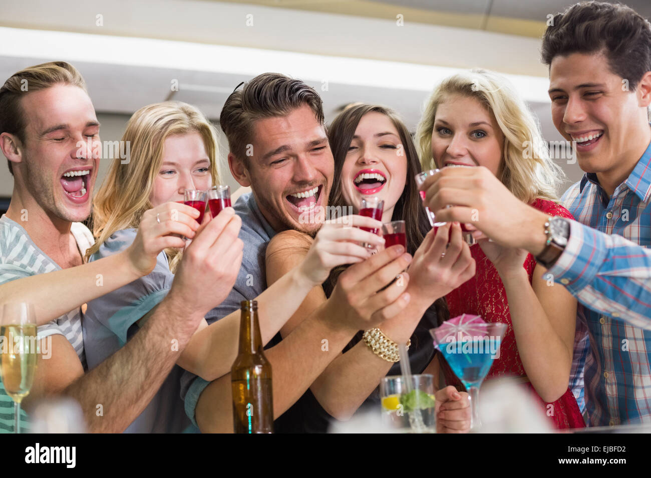 Happy friends having a drink together Stock Photo - Alamy