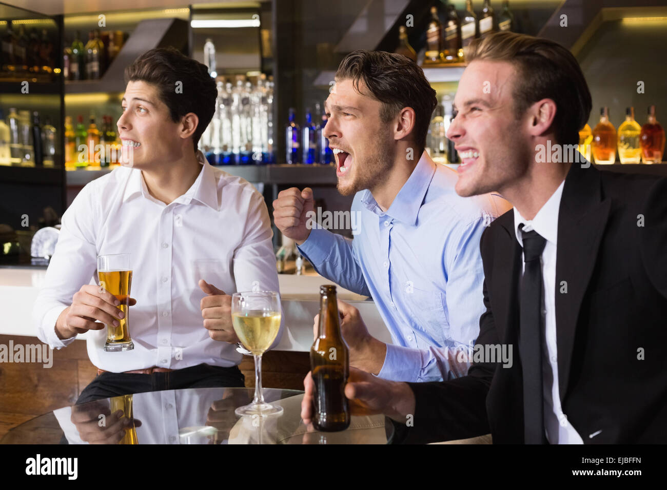 Handsome friends having a drink together Stock Photo - Alamy