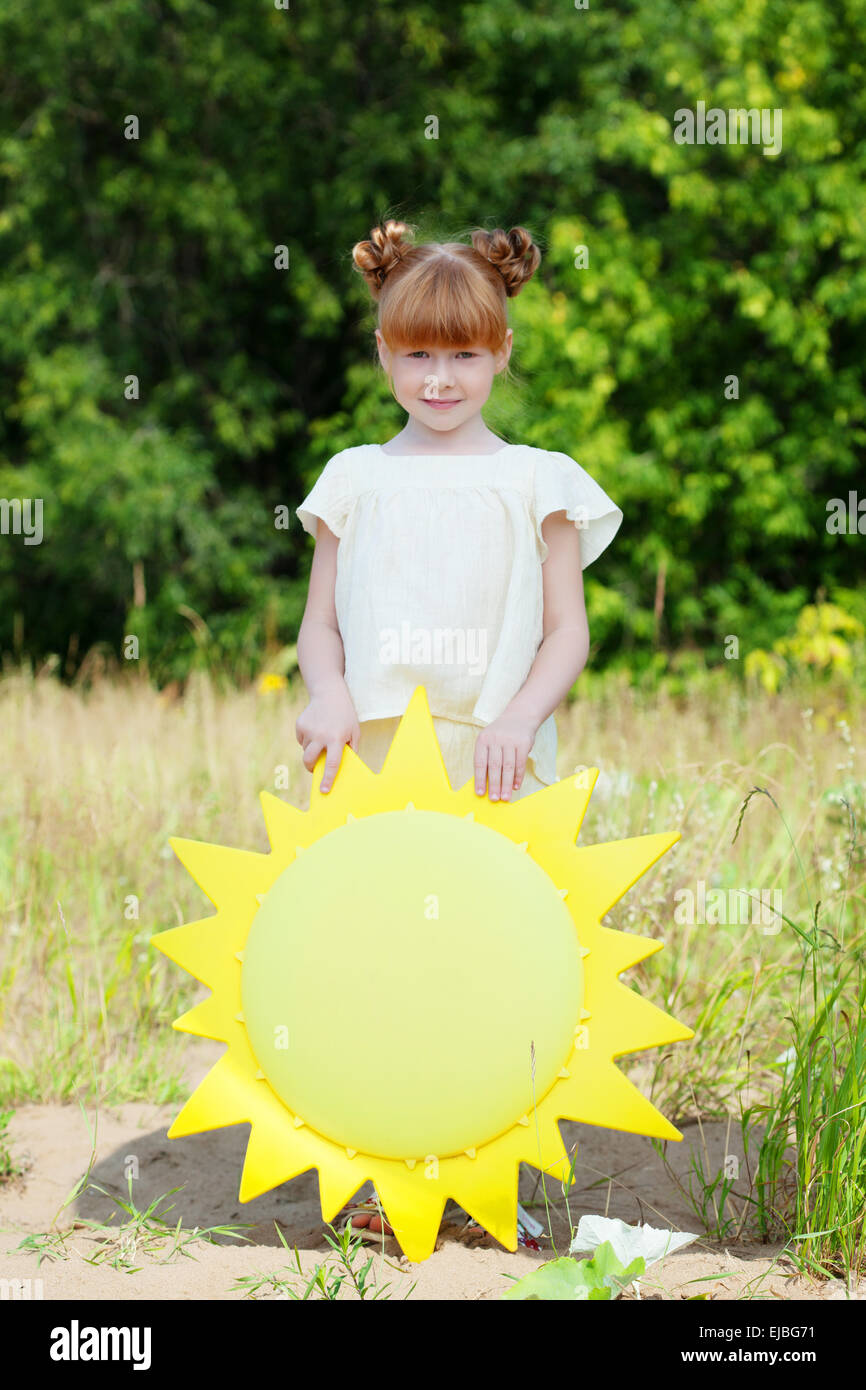 Pretty red-haired girl posing with paper sun Stock Photo - Alamy