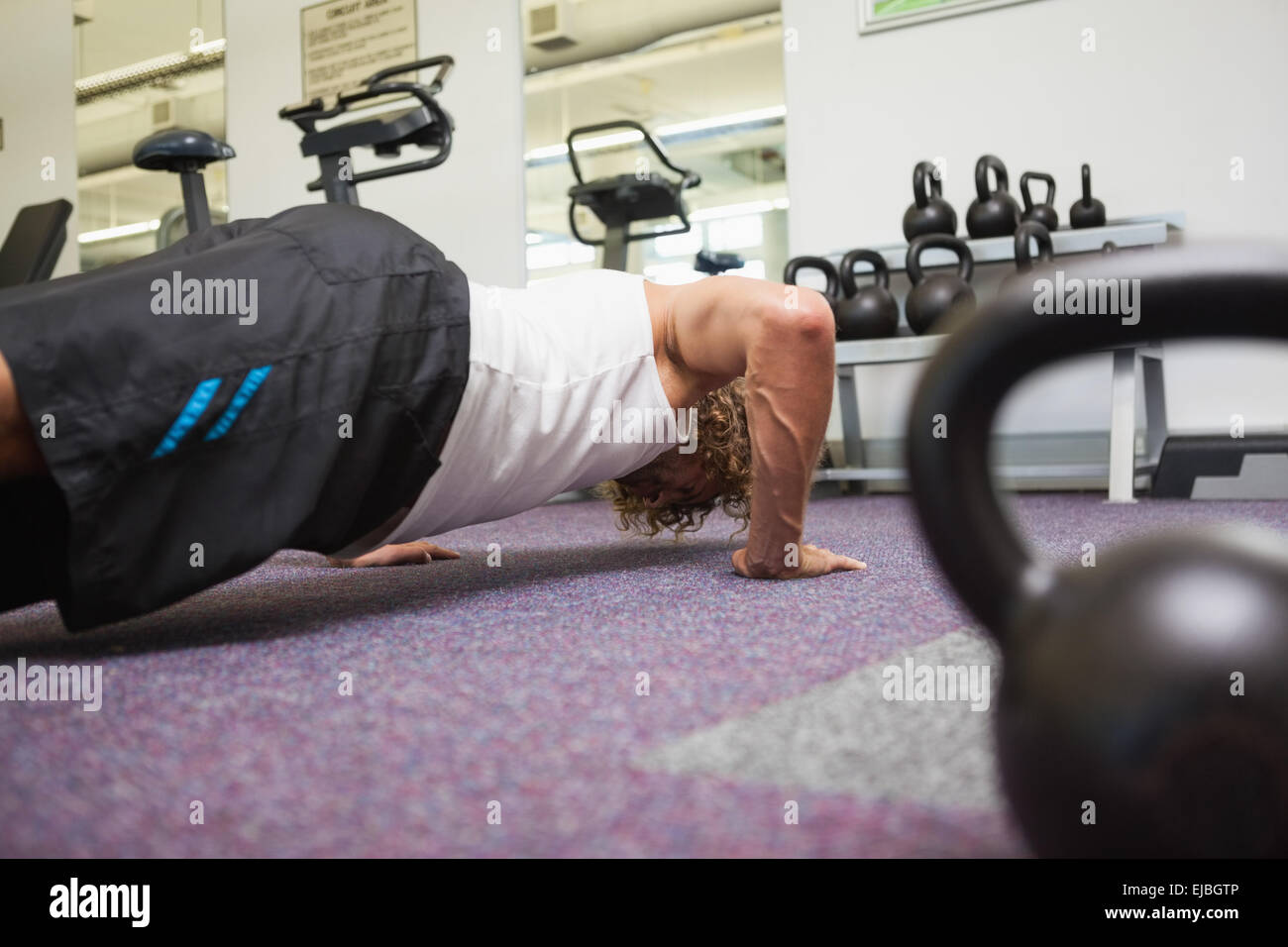 Side view of man doing push ups in gym Stock Photo - Alamy