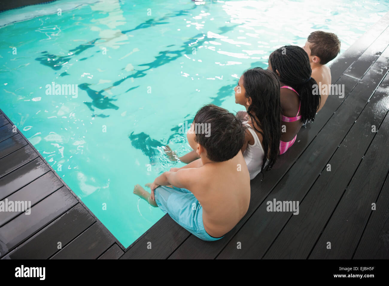 Cute little kids sitting poolside Stock Photo - Alamy