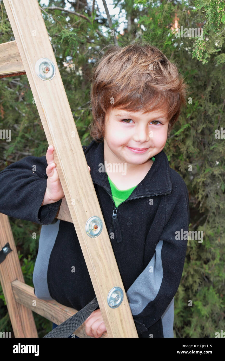The beautiful blond boy climbed a ladders Stock Photo - Alamy