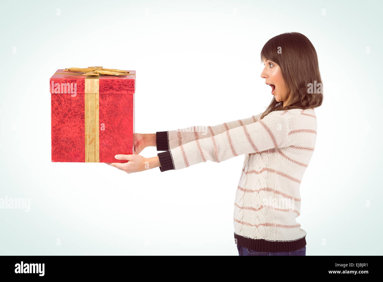 Surprised brunette holding a gift Stock Photo - Alamy
