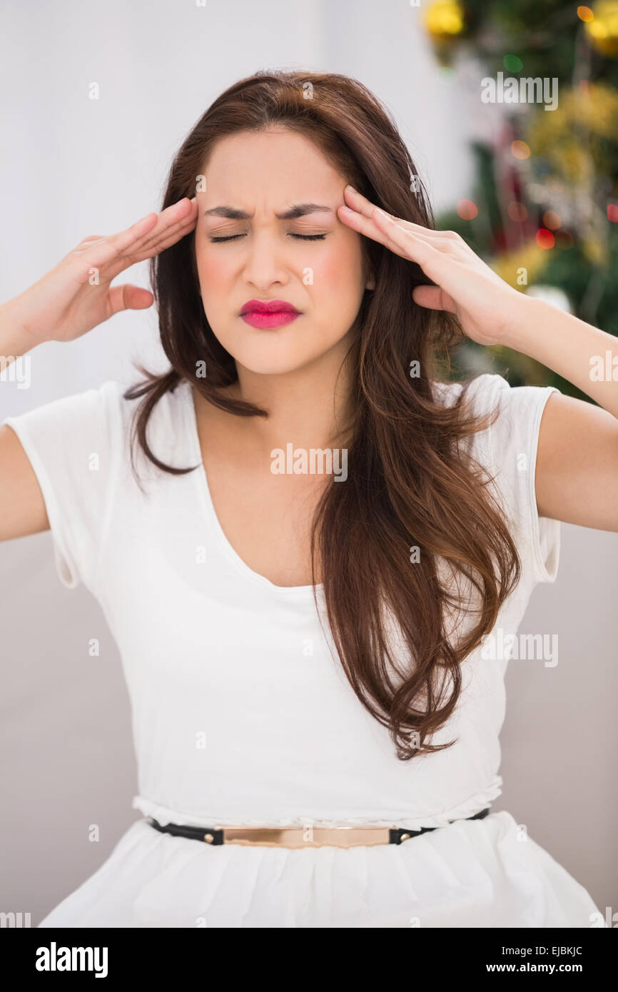 Brunette getting a headache on christmas day Stock Photo - Alamy