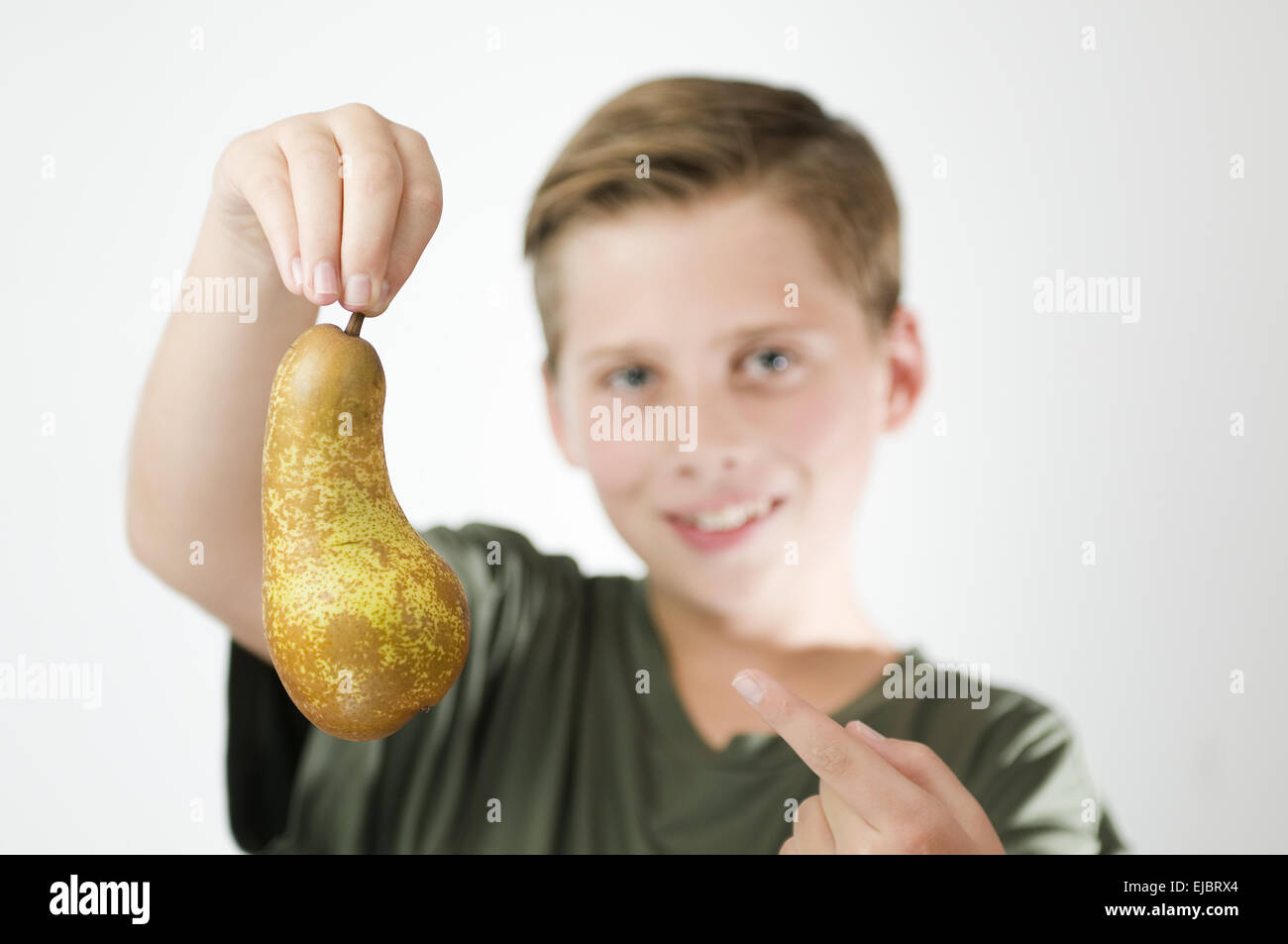 Boy points to a pear on white Stock Photo - Alamy