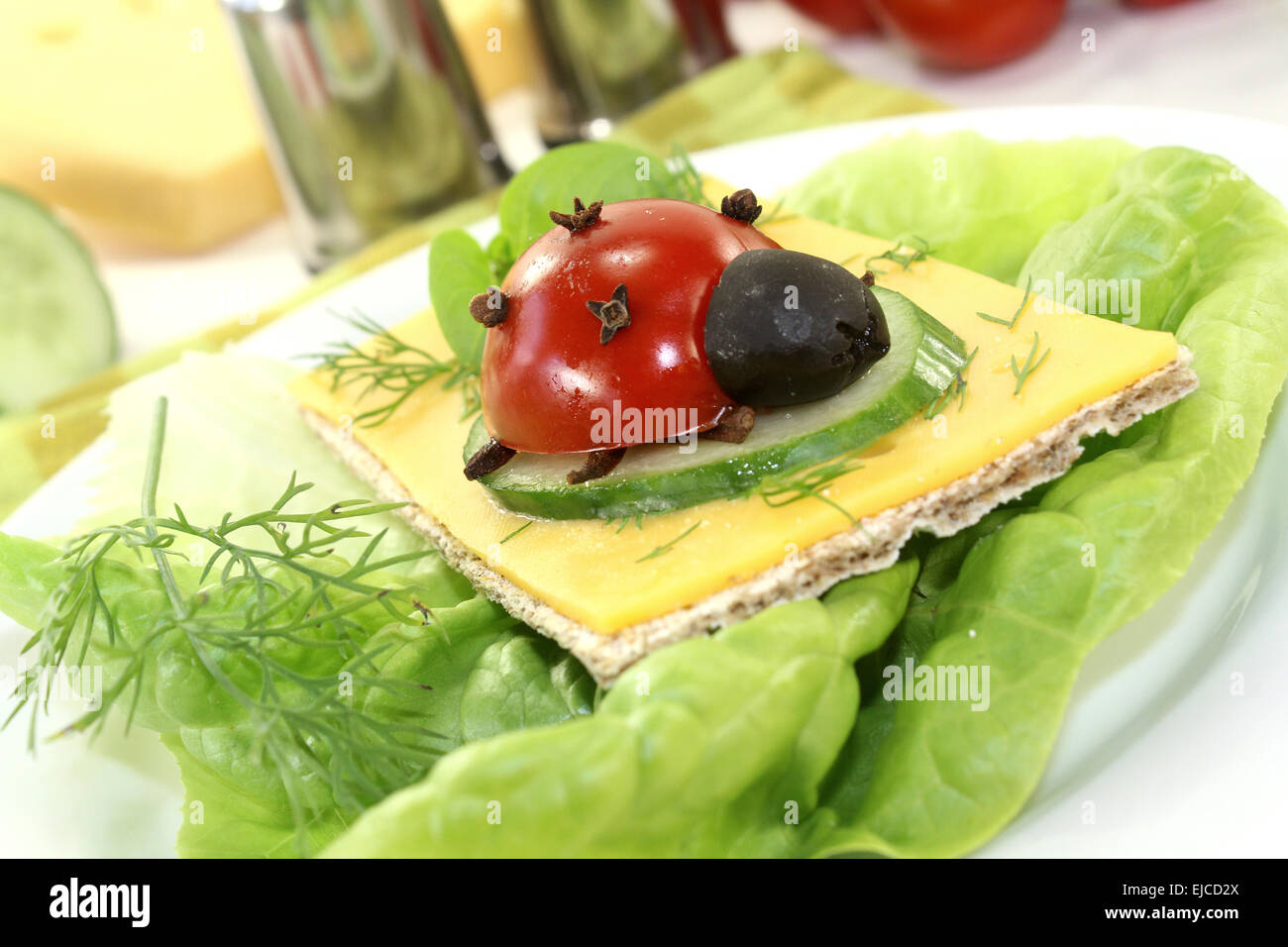 Crispbread with cheese, lettuce and ladybug Stock Photo - Alamy