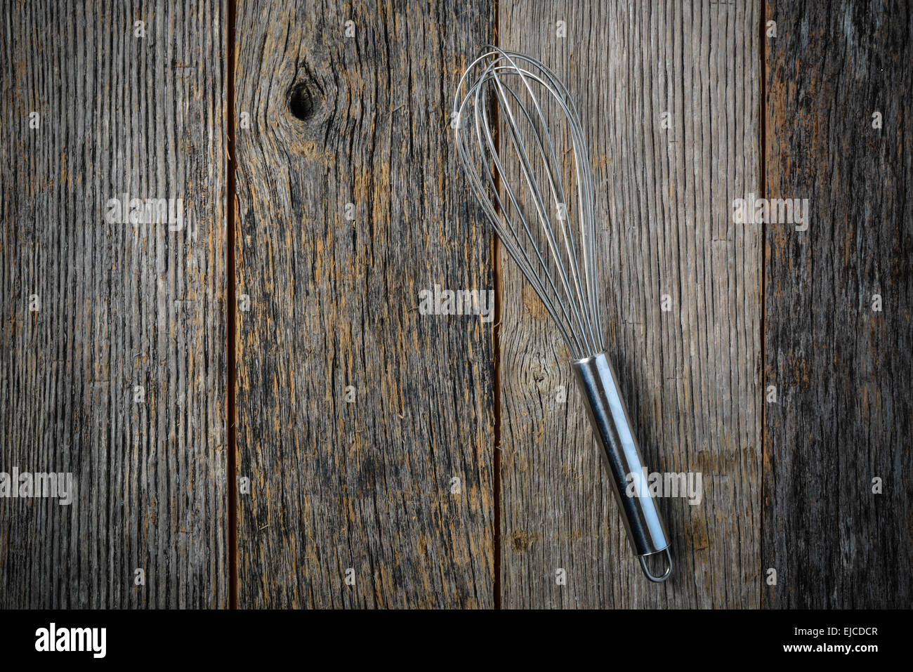 Metal Whisk on Rustic Wood Background Stock Photo - Alamy