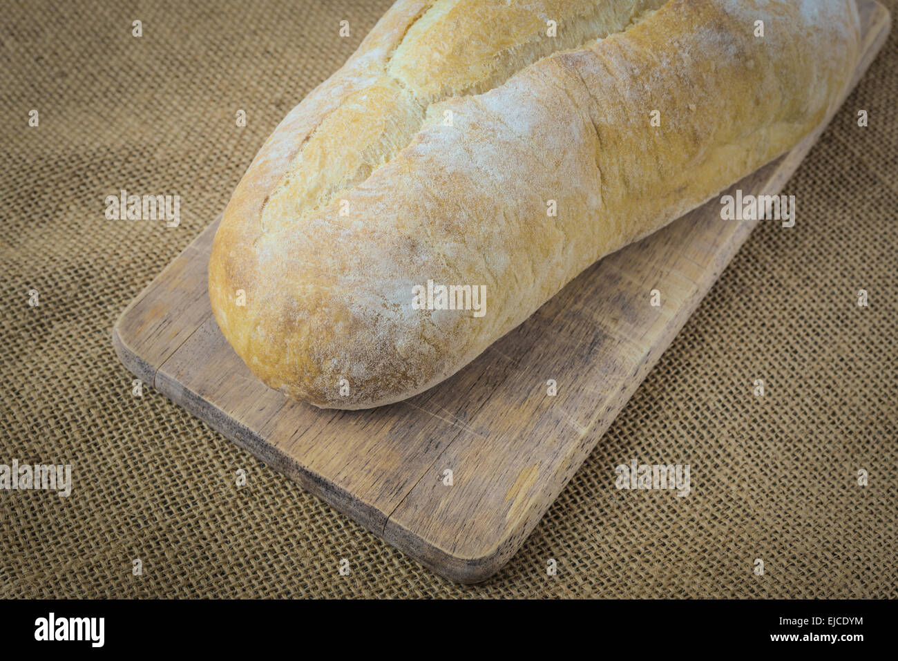 Bread on Bread Board on Burlap Background Stock Photo - Alamy