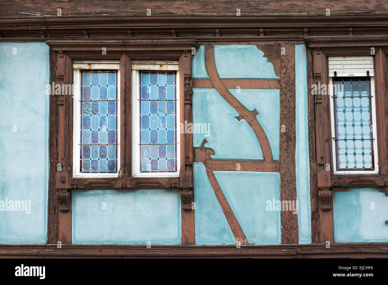Blue half-timbered medieval building with stained glass window, Colmar ...