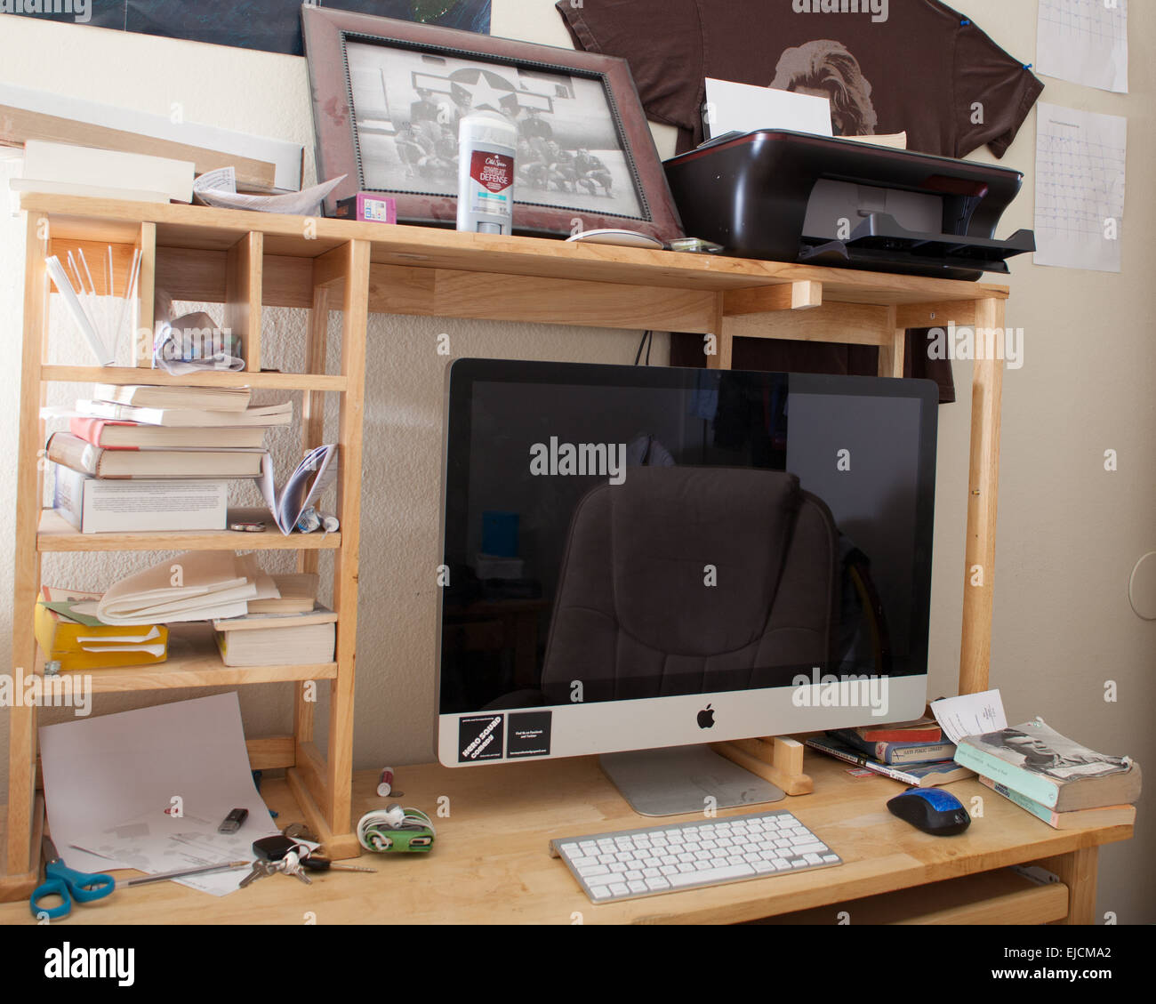 A male college students desk with Imac computer, Ipod, and a copy of ...